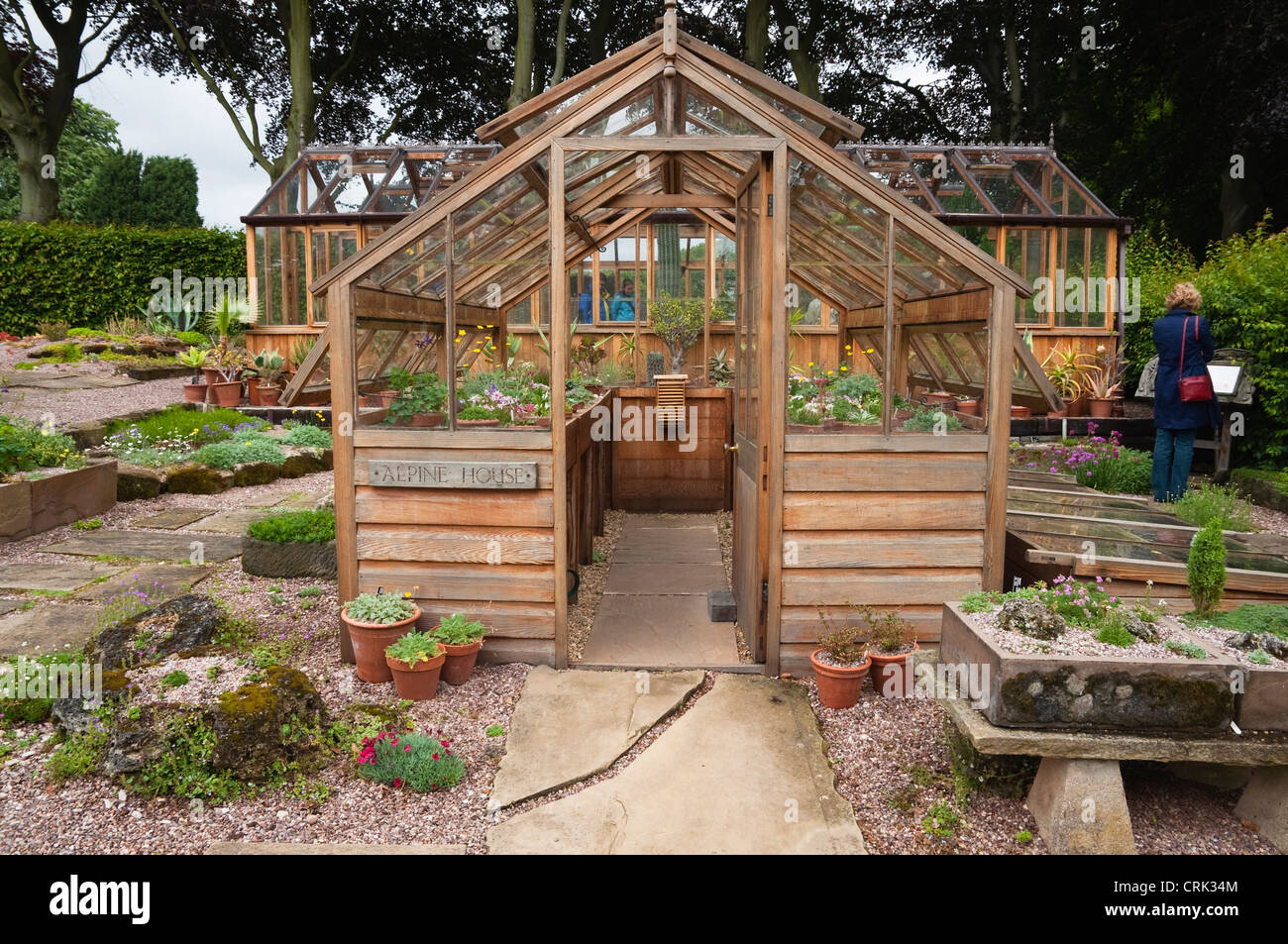 The Alpine House - a traditional wooden greenhouse, surrounded by a ...
