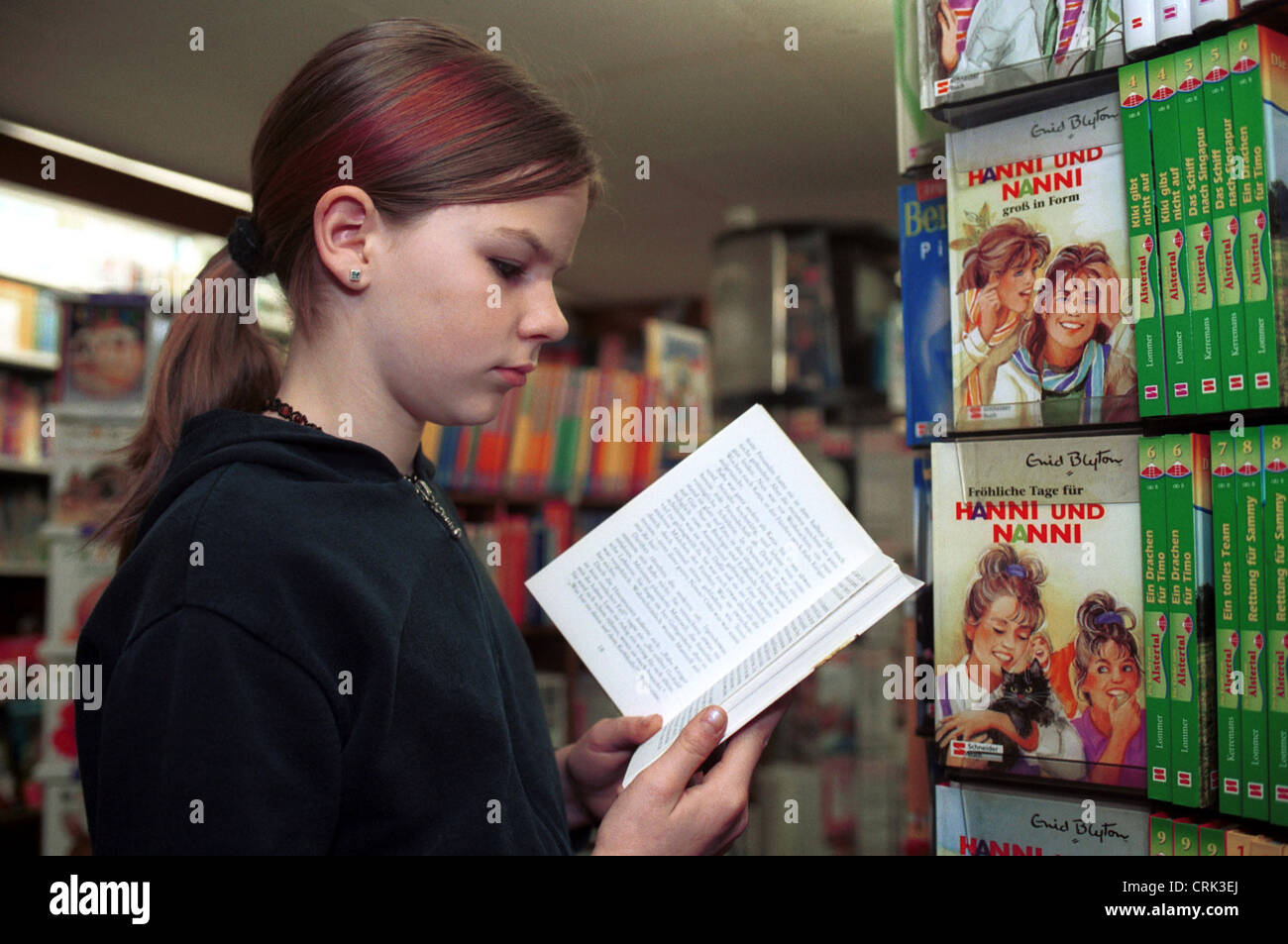 Reading girl in a bookstore Stock Photo - Alamy