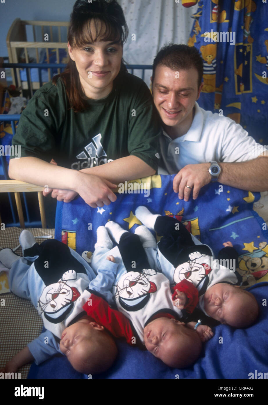 Identical triplets in Berlin with parents Stock Photo - Alamy