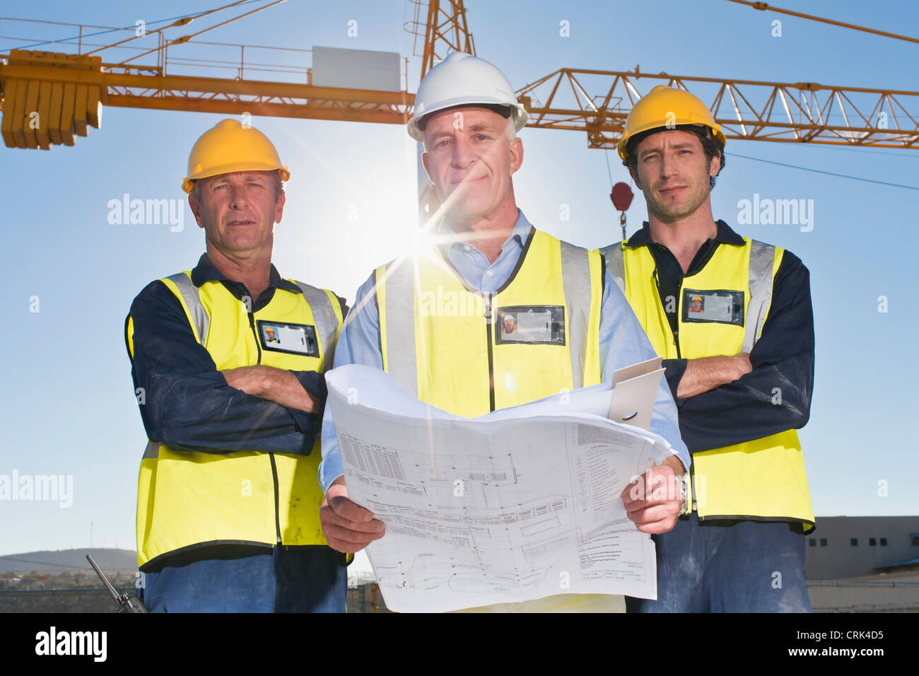 Workers reading blueprints on site Stock Photo - Alamy