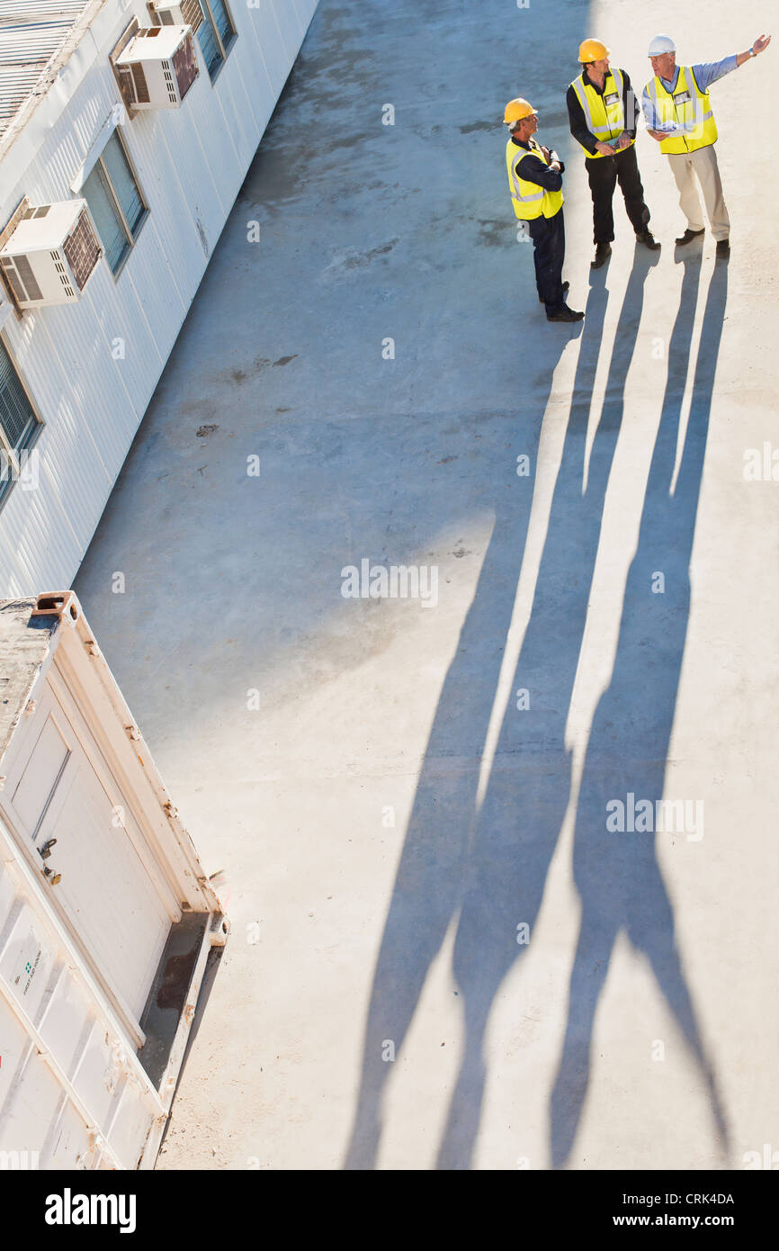 Workers casting shadows on site Stock Photo - Alamy