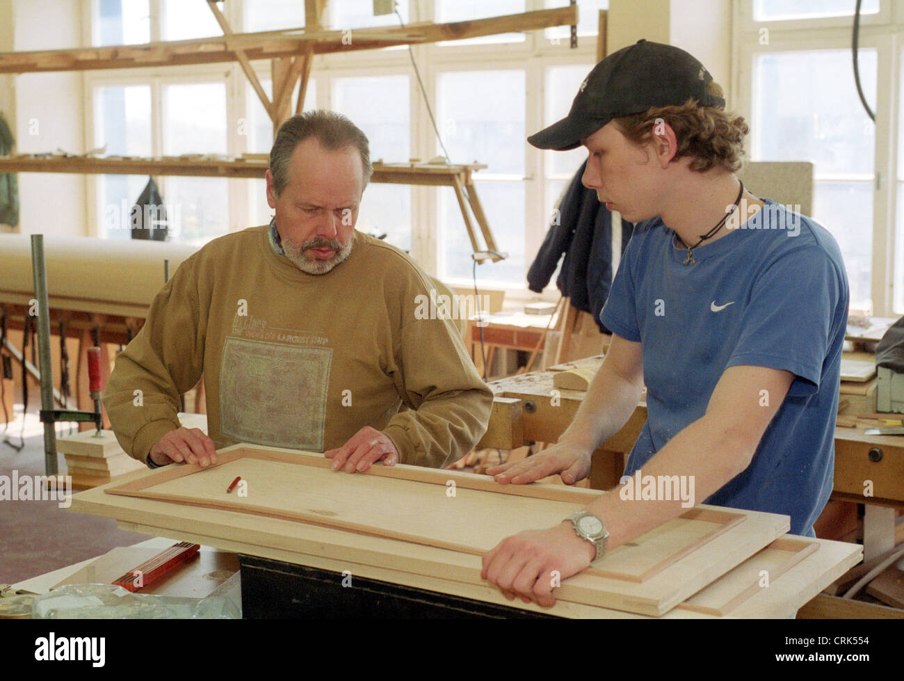 Berlin, a carpenter apprentice is instructed by his master Stock Photo ...