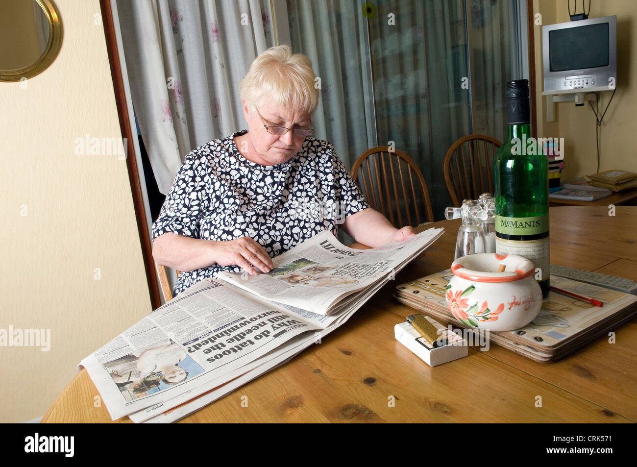 Elderly woman reading a newspaper Stock Photo - Alamy