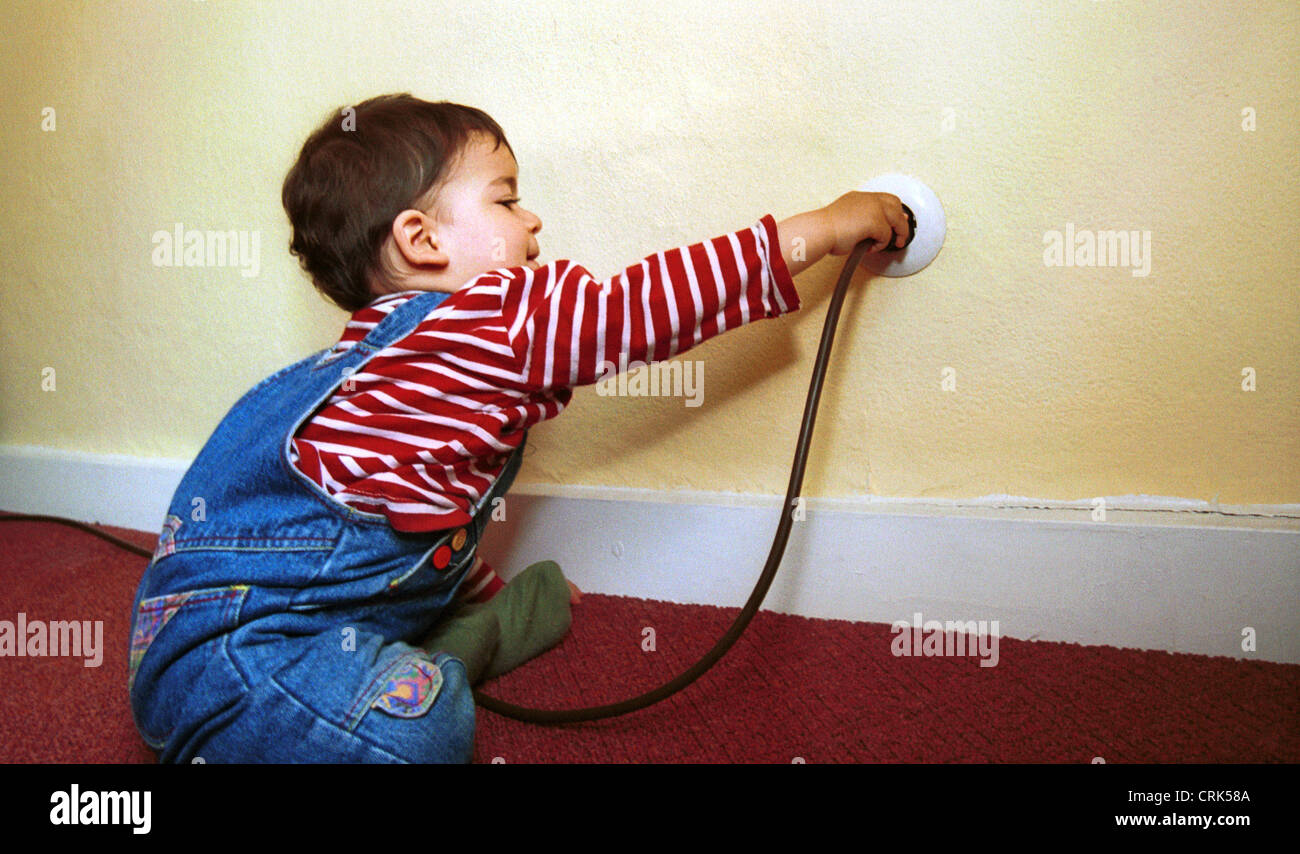 Small child playing with socket Stock Photo - Alamy