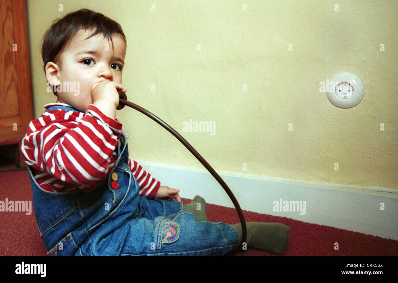 Small child playing with socket Stock Photo - Alamy