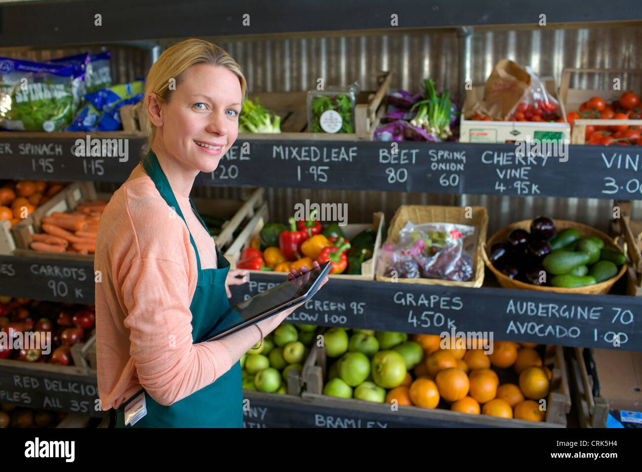 Grocer using tablet computer in store Stock Photo - Alamy