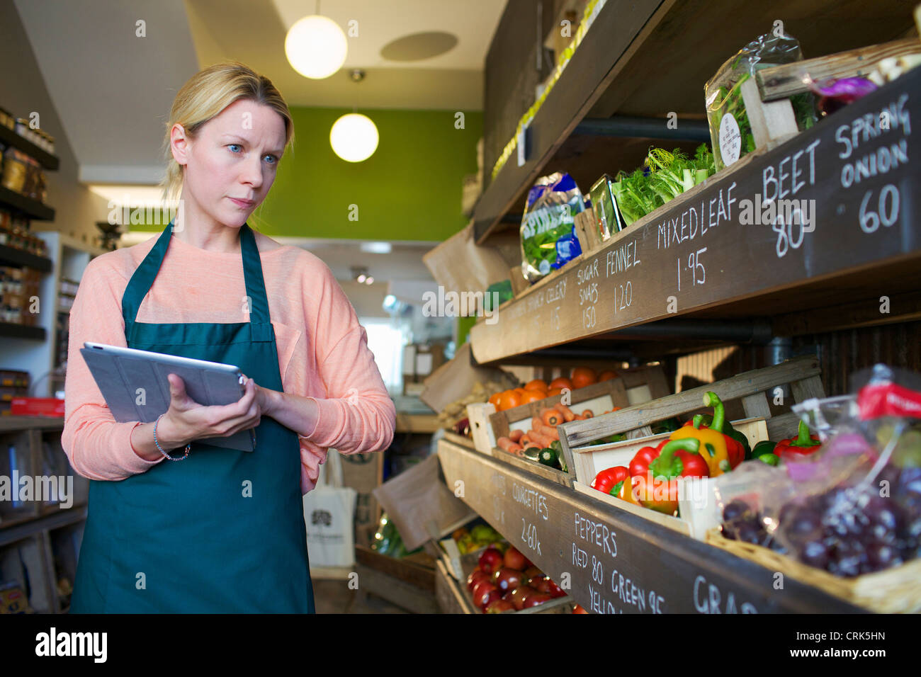 Grocer using tablet computer in store Stock Photo - Alamy