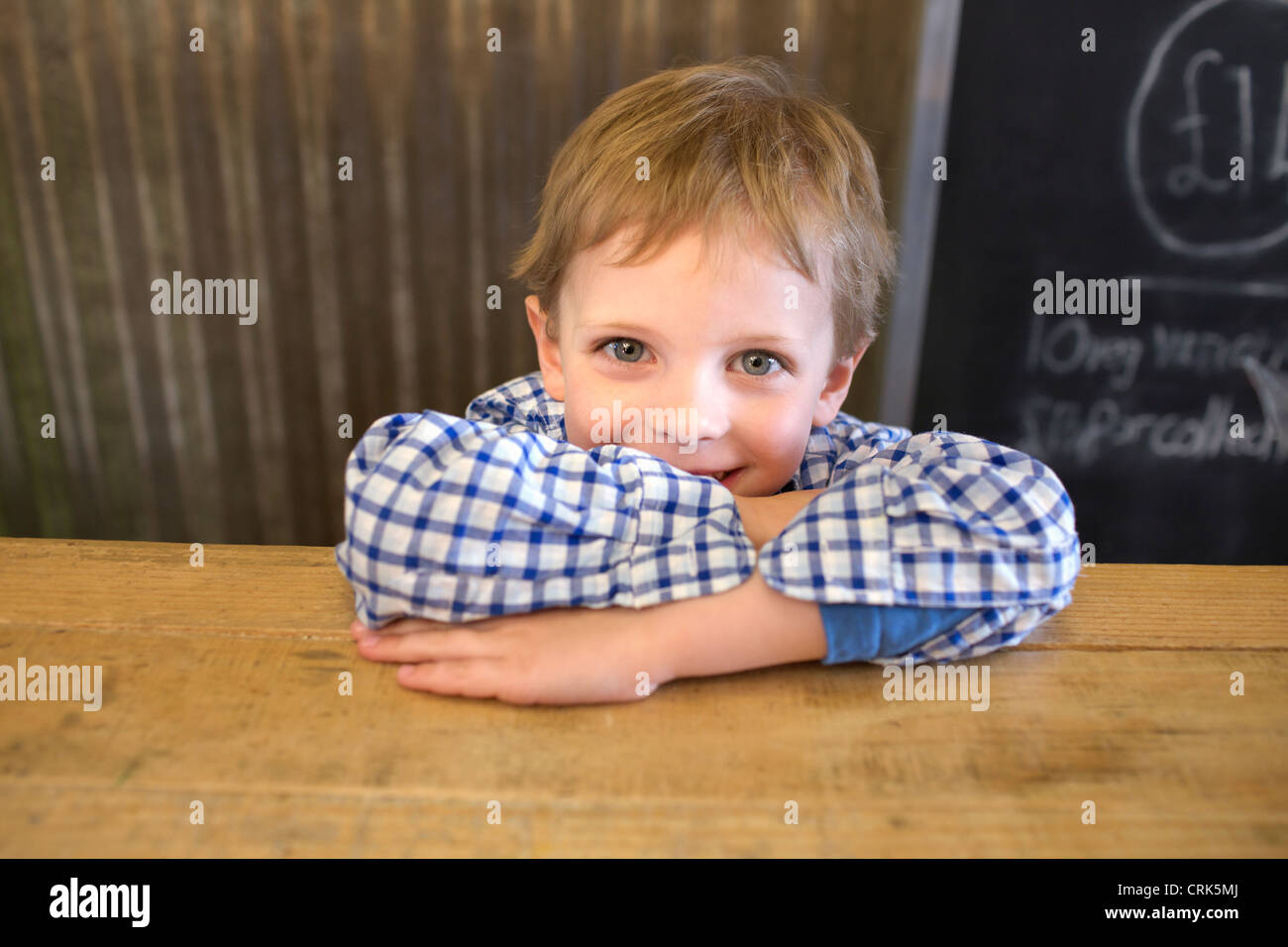 Smiling boy leaning on counter Stock Photo - Alamy