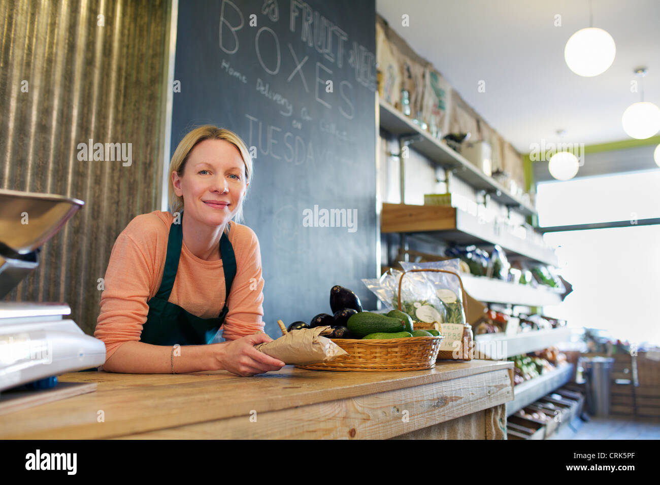 Grocer working behind counter at store Stock Photo - Alamy