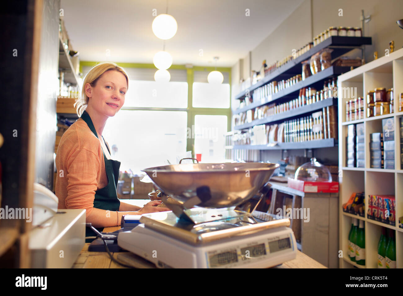 Grocer working behind counter at store Stock Photo - Alamy