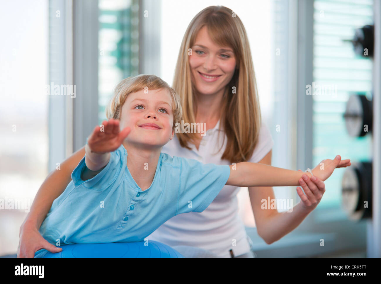 Trainer working with boy in gym Stock Photo - Alamy