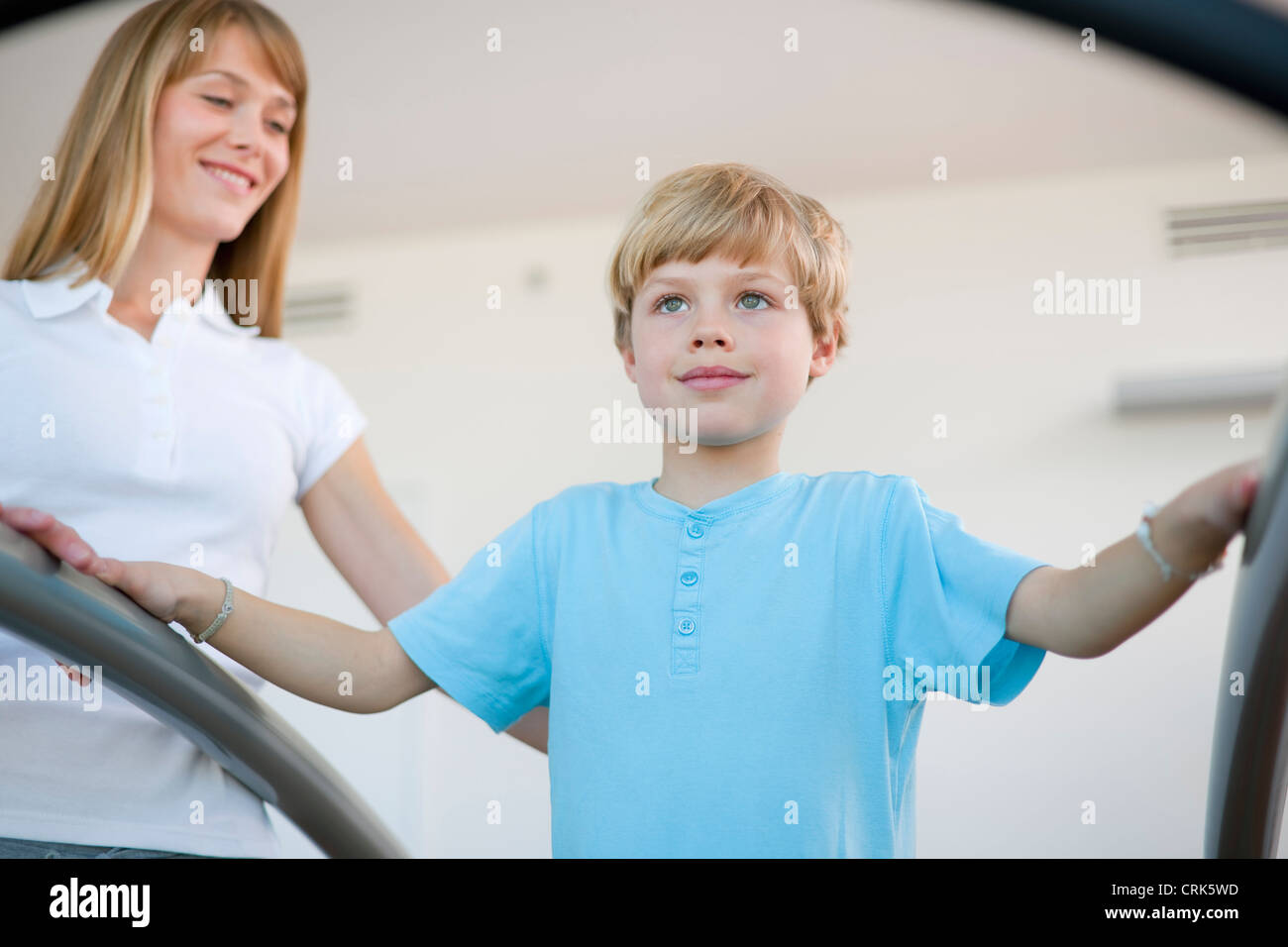 Trainer working with boy in gym Stock Photo - Alamy