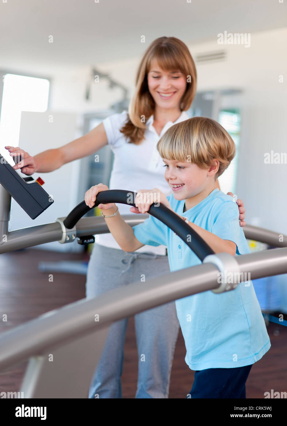 Trainer working with boy in gym Stock Photo - Alamy
