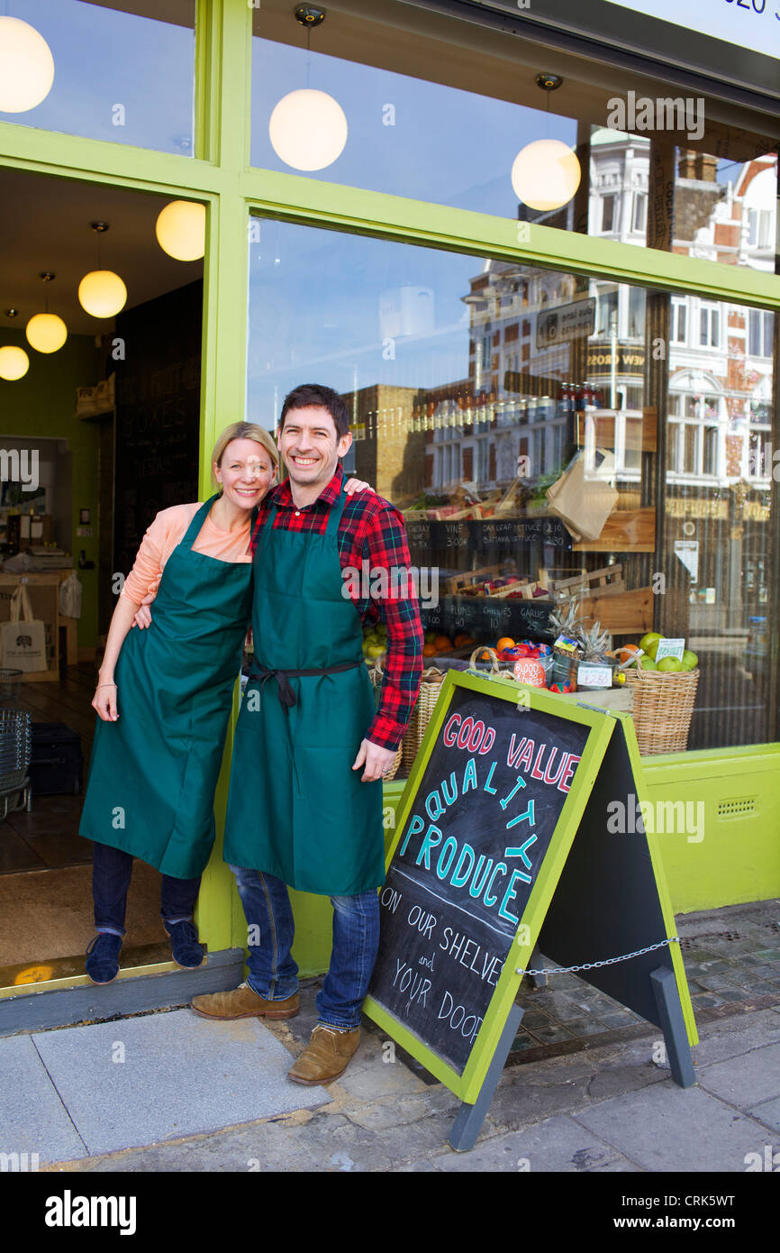 Smiling grocers standing outside store Stock Photo - Alamy