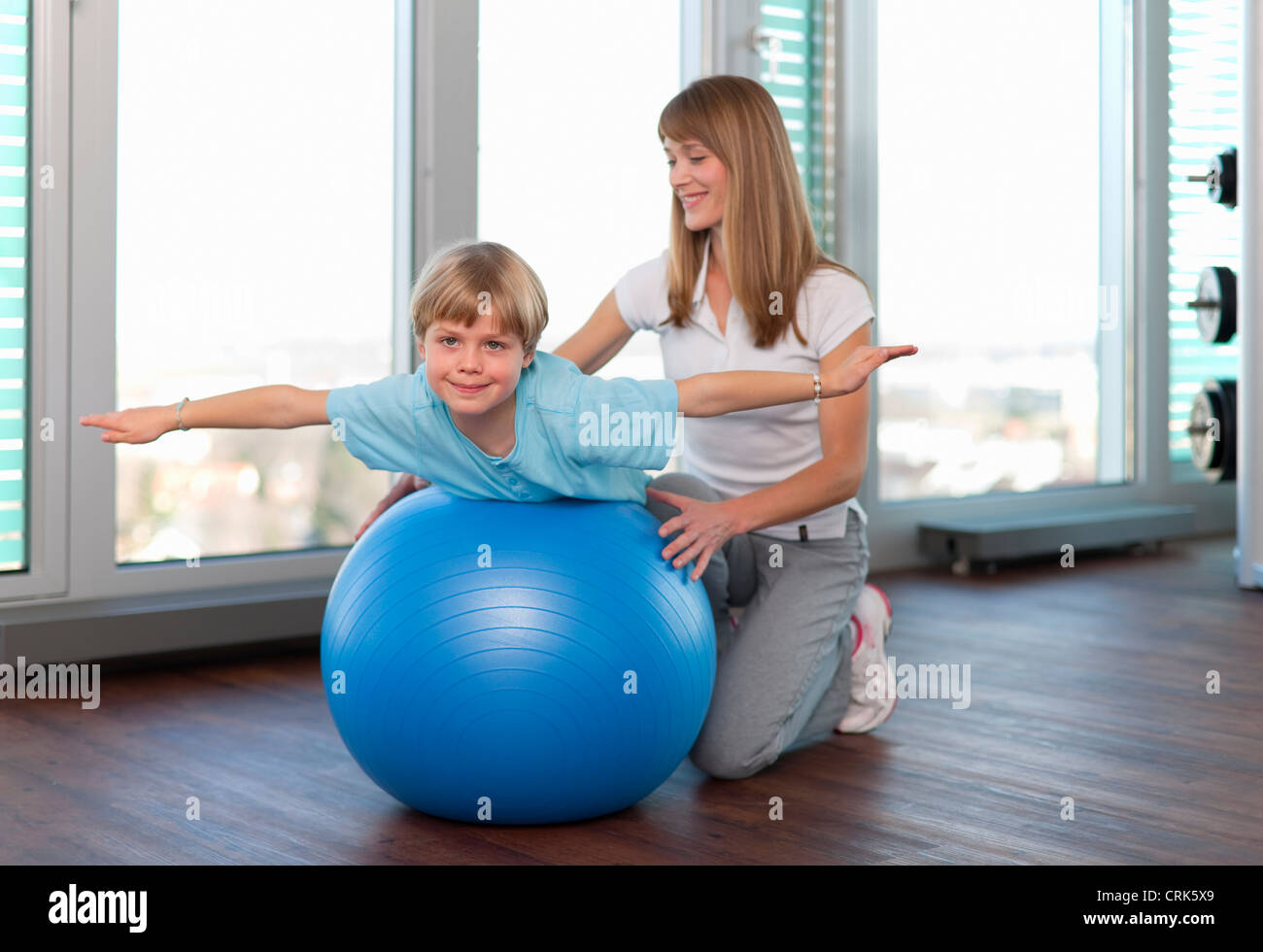 Trainer working with boy in gym Stock Photo - Alamy