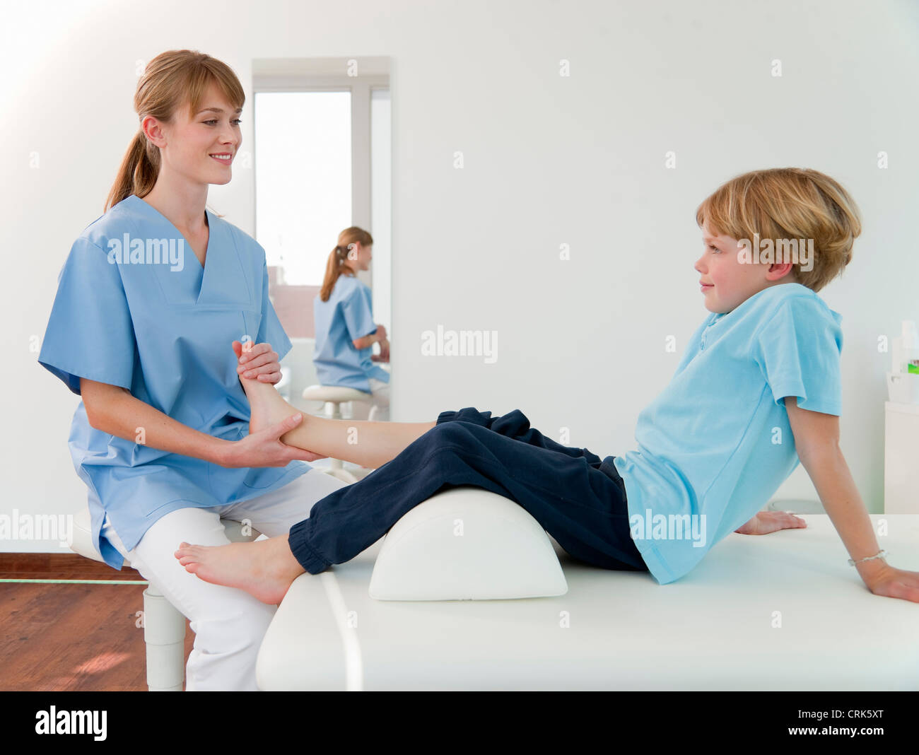 Doctor examining boys feet in office Stock Photo - Alamy