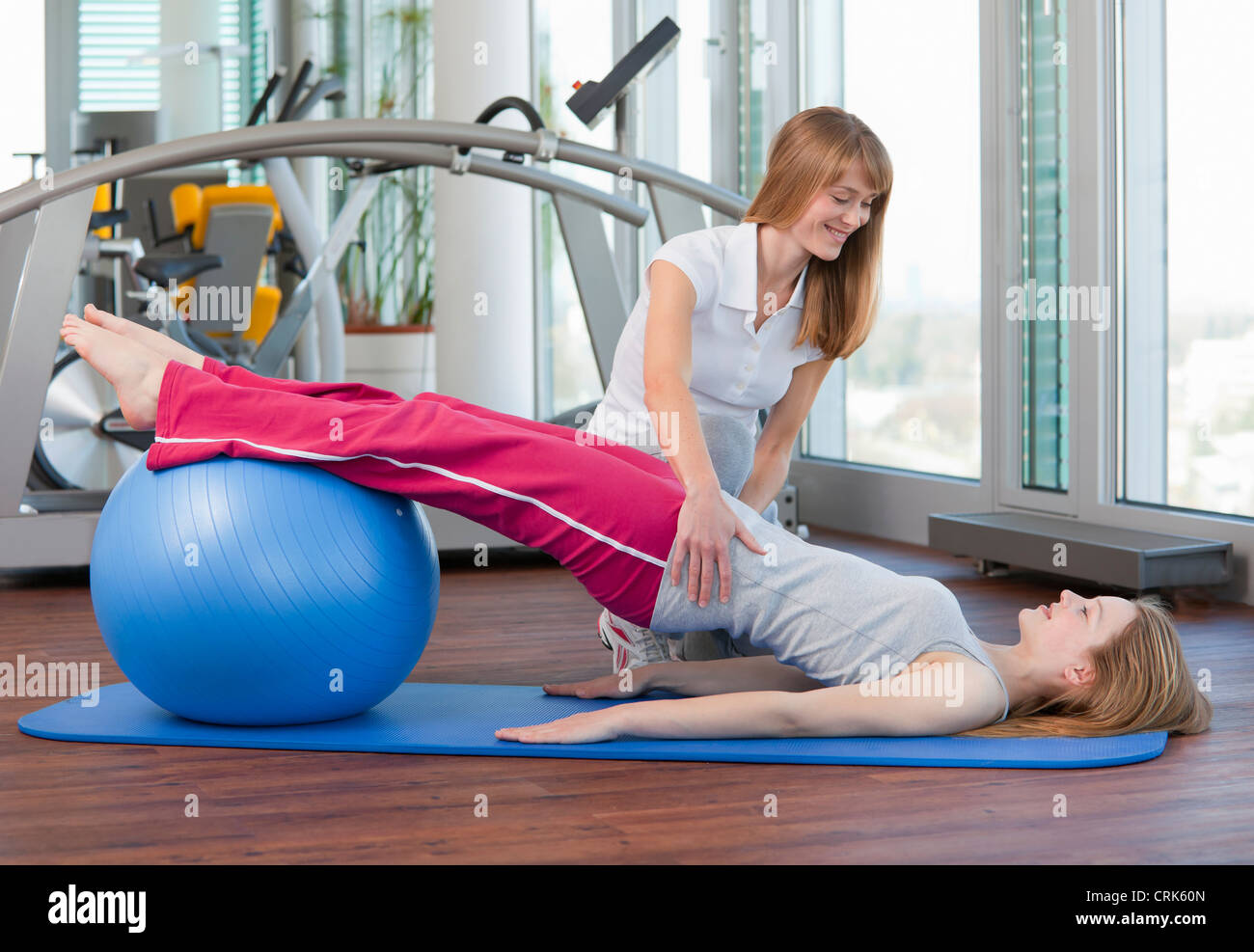 Trainer working with girl in gym Stock Photo - Alamy