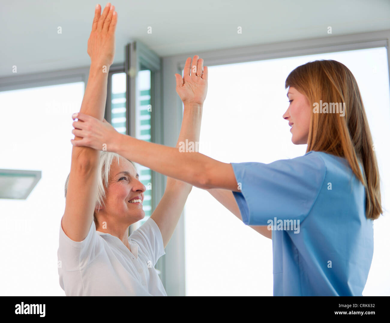 Doctor examining womans arms in office Stock Photo - Alamy