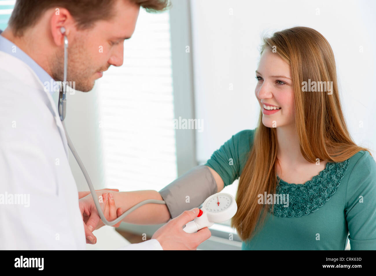 Doctor taking girls blood pressure Stock Photo - Alamy
