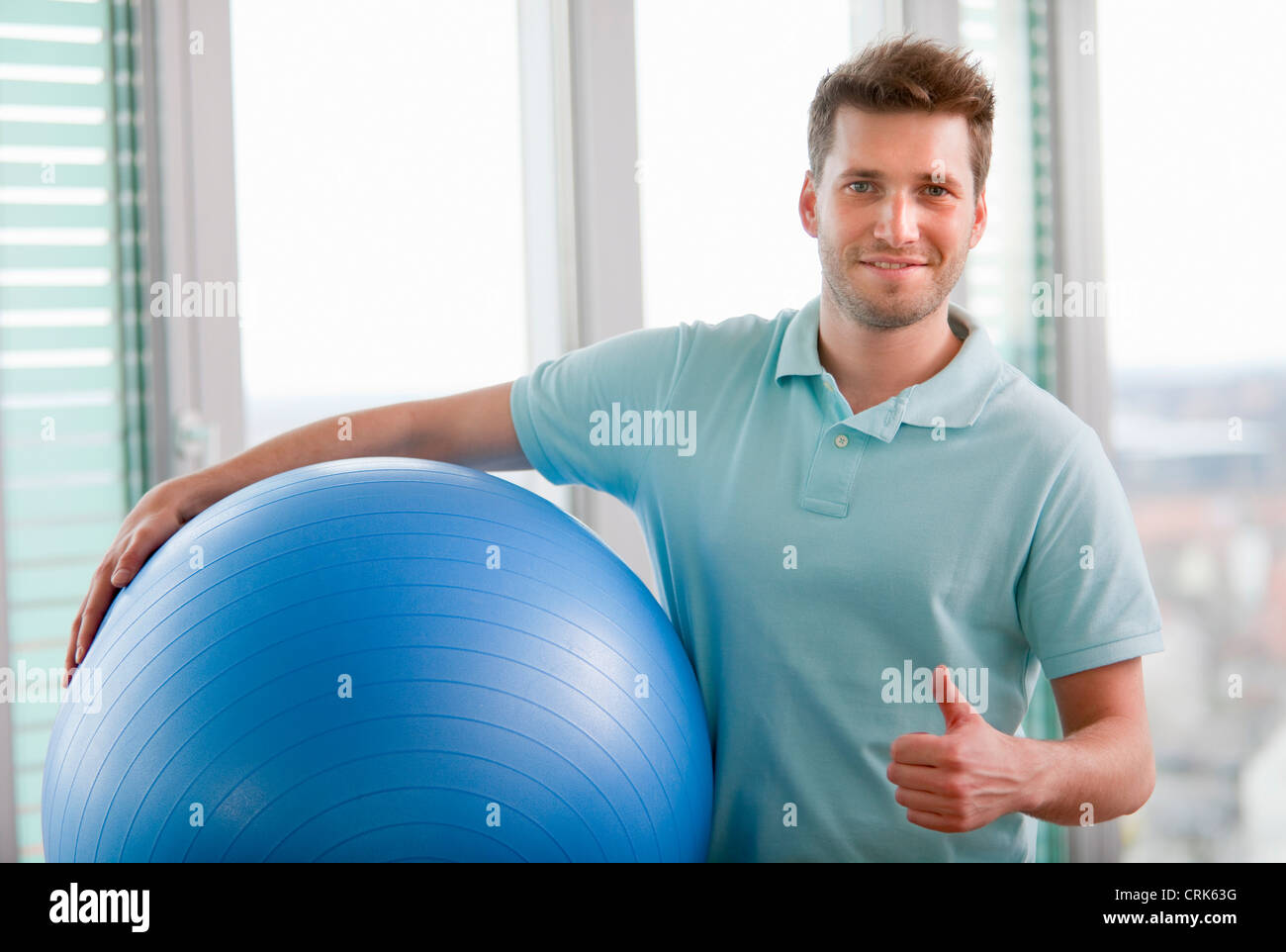 Man carrying exercise ball in gym Stock Photo - Alamy