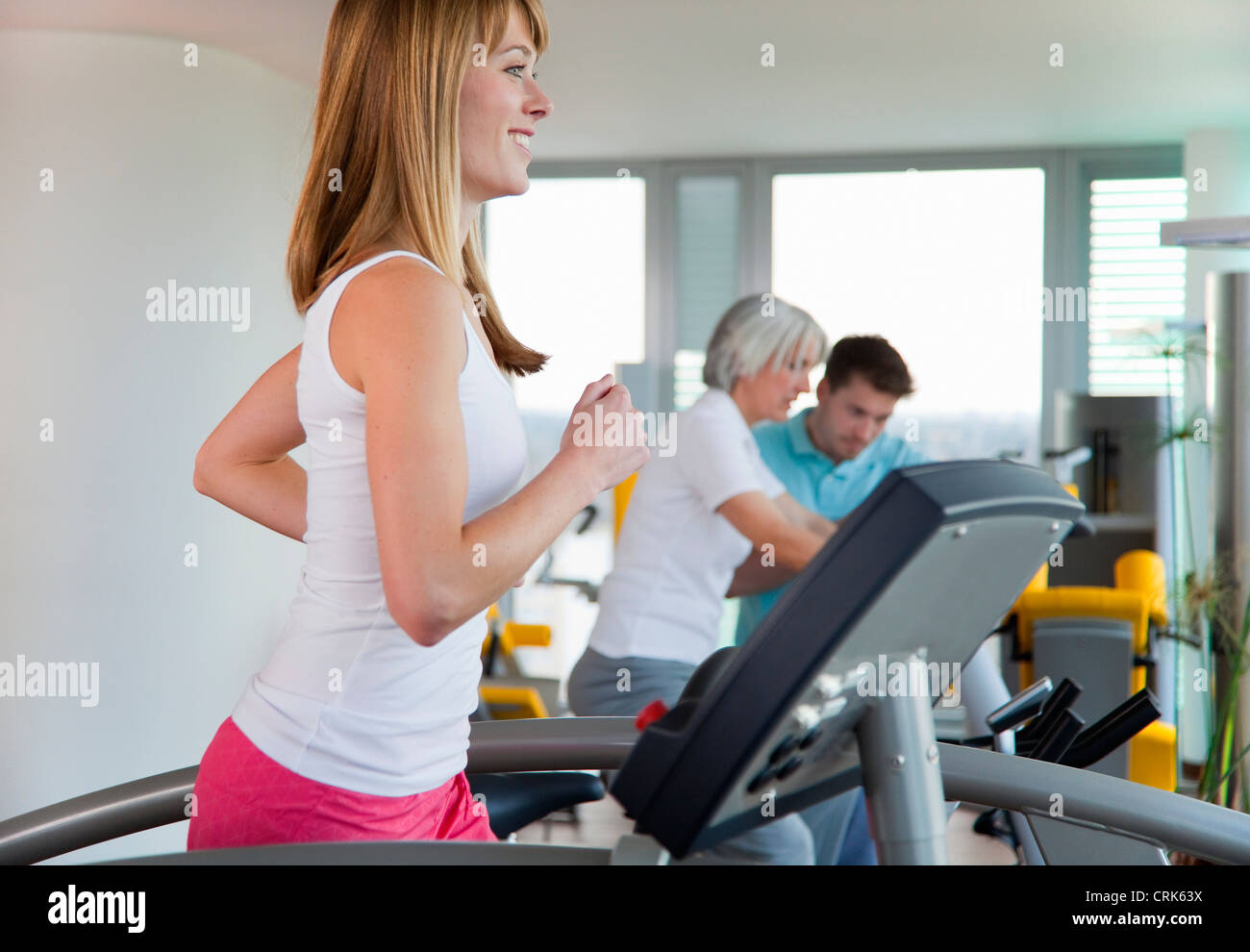 Woman using treadmill in gym Stock Photo - Alamy