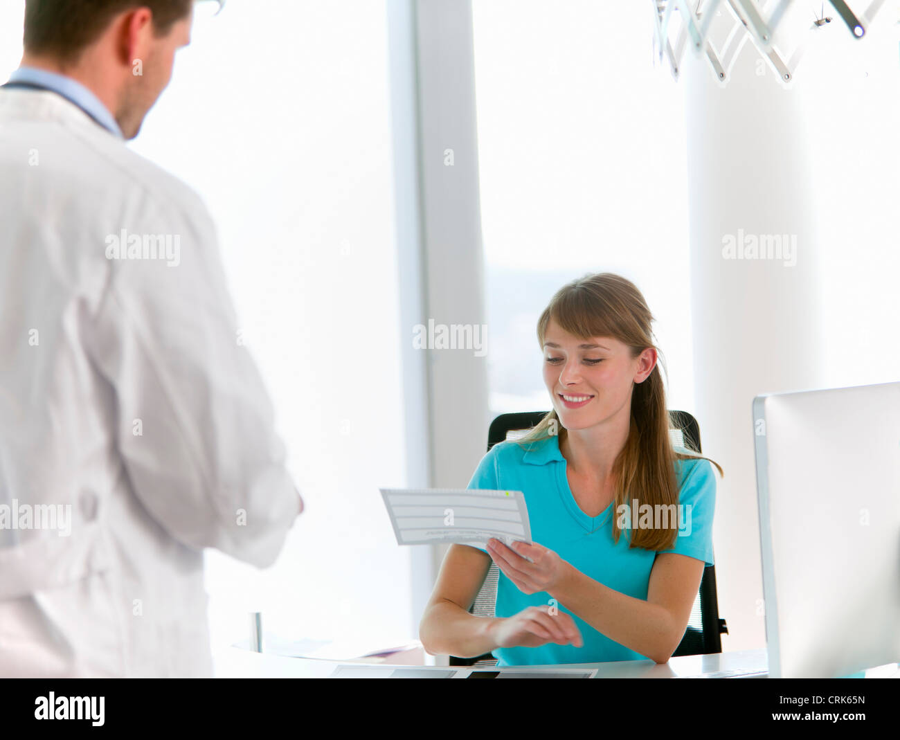 Doctor talking to receptionist in office Stock Photo - Alamy