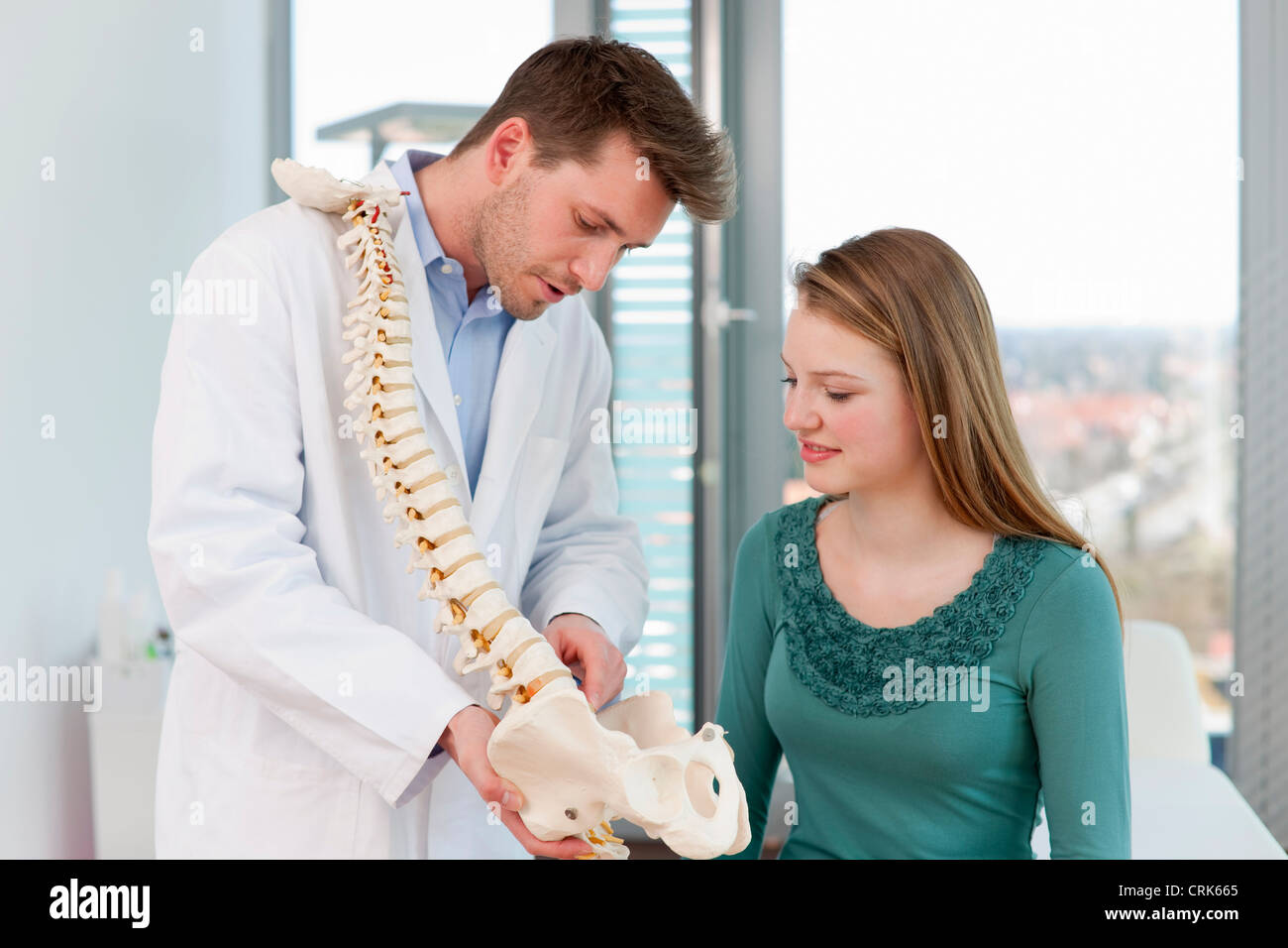 Doctor showing spine model to patient Stock Photo - Alamy