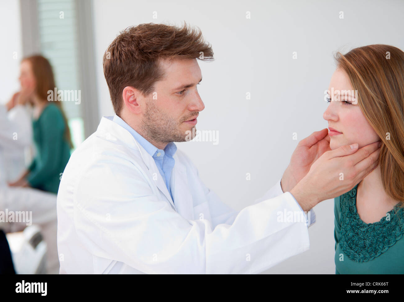Doctor examining woman in office Stock Photo - Alamy