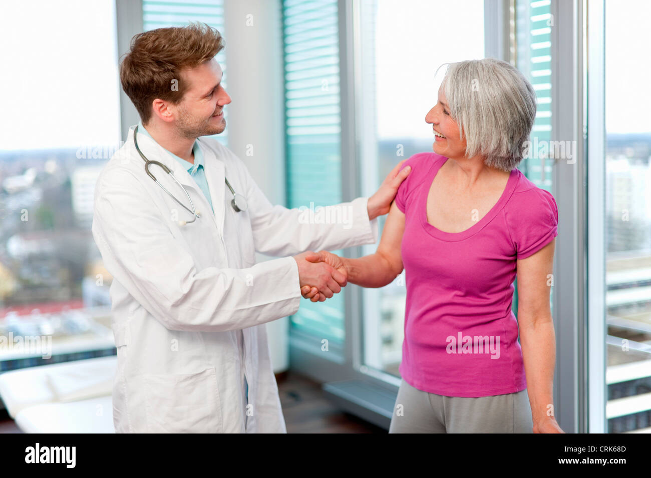 Doctor shaking womans hand in office Stock Photo - Alamy