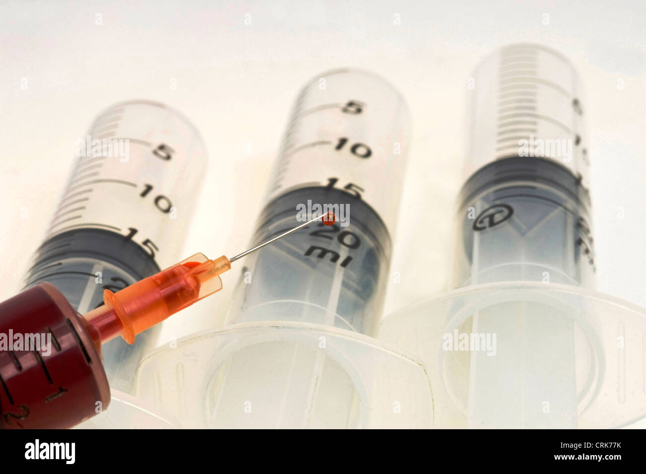 syringes, one having a red liquid in Stock Photo - Alamy