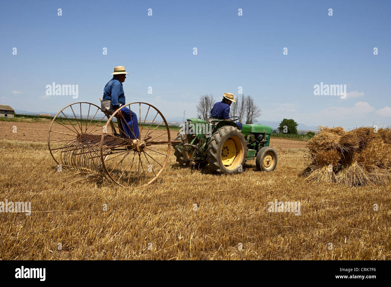 Old agricultural machine harvesting with tractor Stock Photo - Alamy