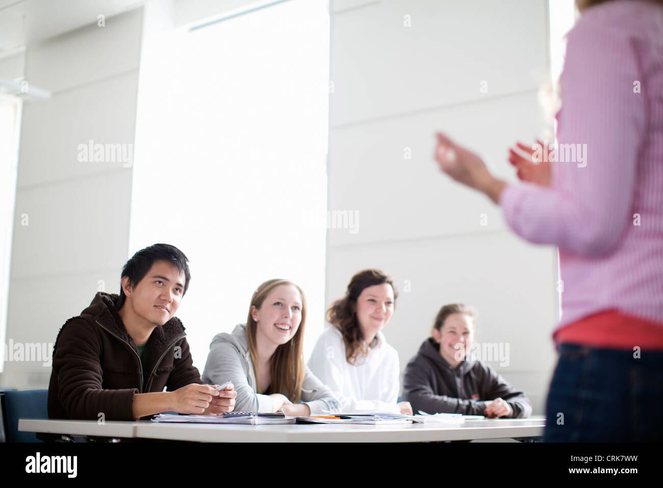Teacher talking to students in class Stock Photo - Alamy