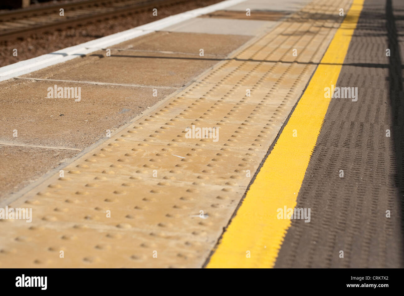 Close up of a railway station platform in England showing the yellow ...