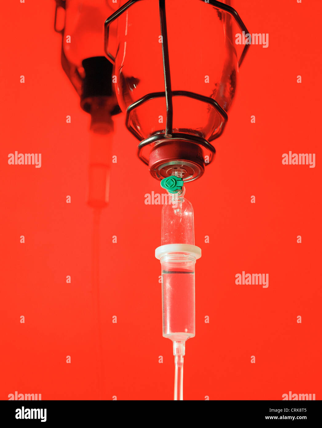 Two full infusion bottles against a red background Stock Photo - Alamy