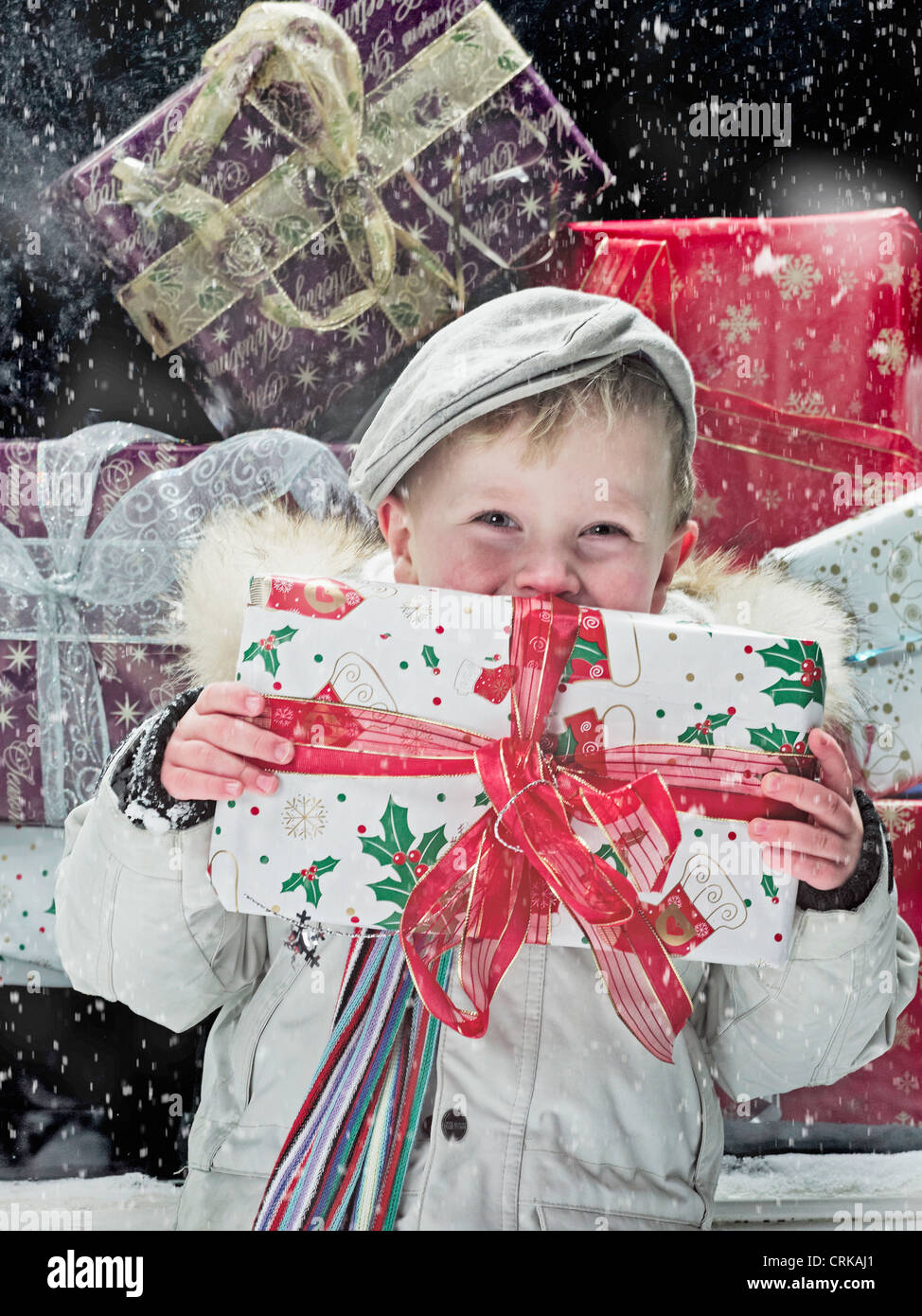 Boy holding Christmas present in snow Stock Photo - Alamy