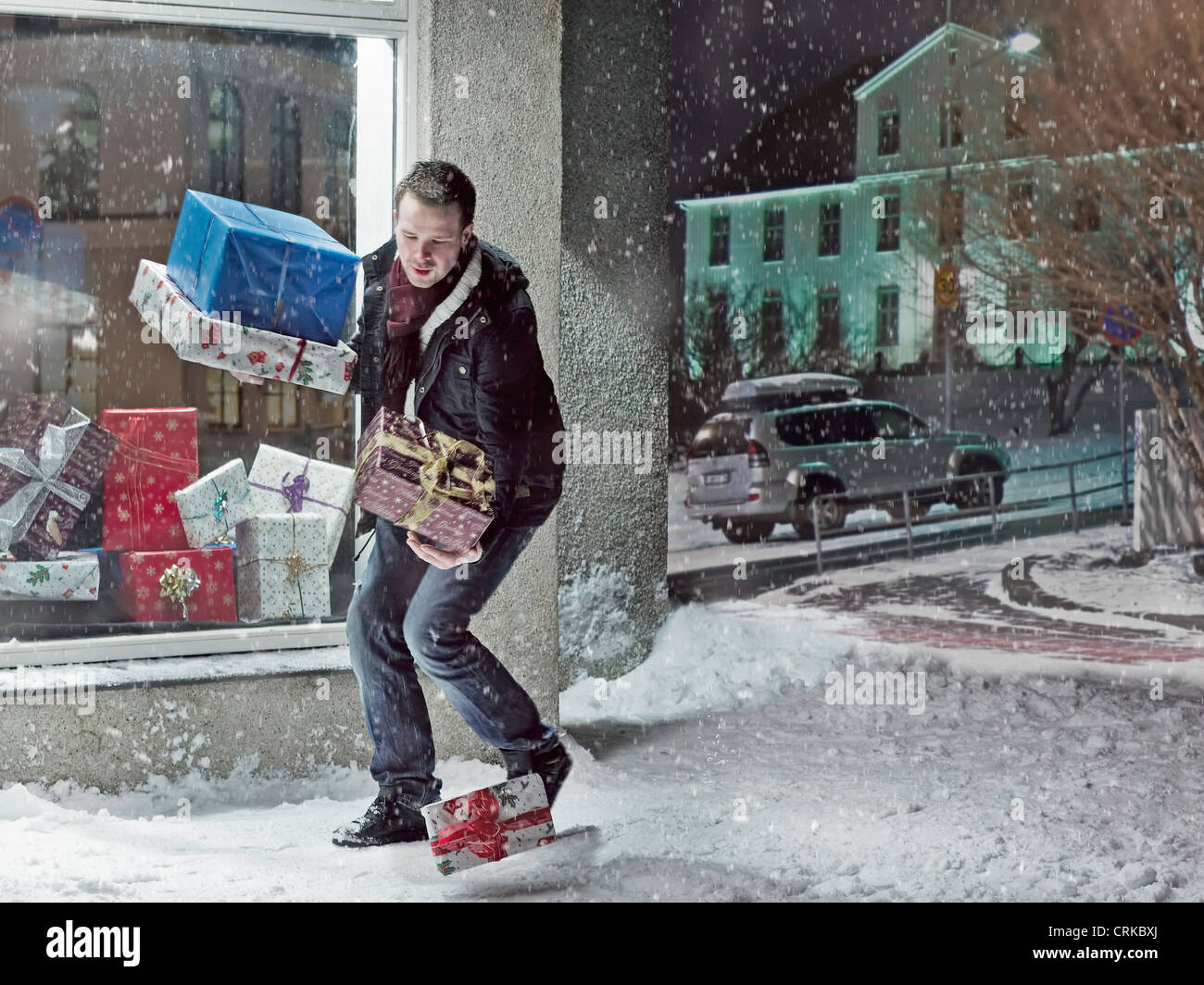 Man dropping Christmas gifts in snow Stock Photo - Alamy