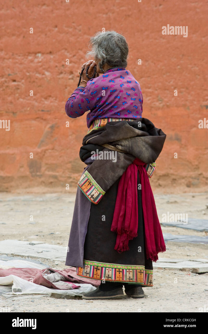 An elderly chinese female Bhuddist pilgrim in prostration at the the ...