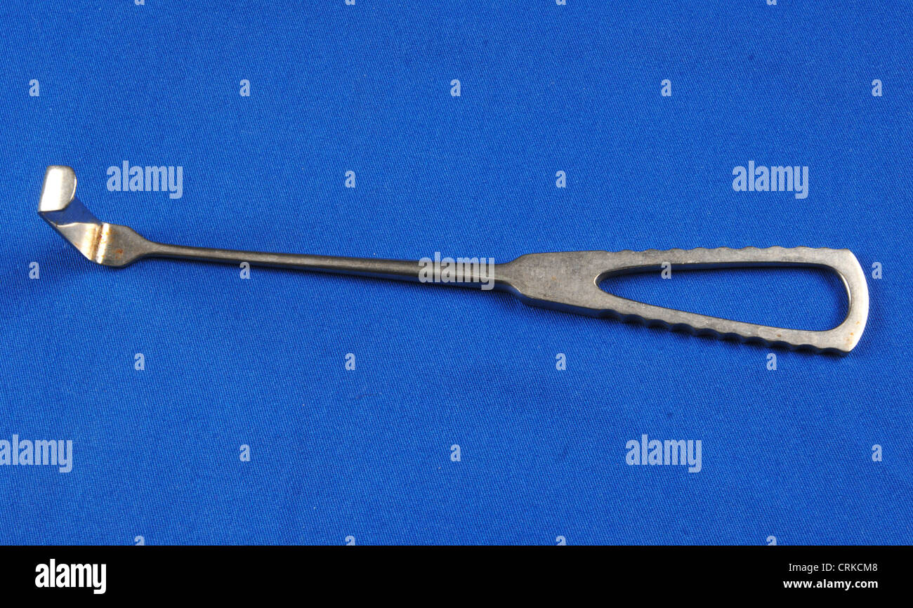 Metal Retractor on a blue background Stock Photo - Alamy