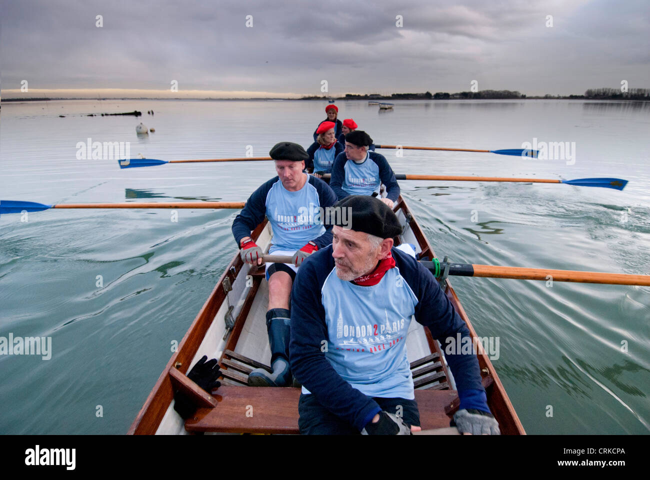 Rowing crew aboard a skiff in Langstone Harbour, near Hayling Island ...