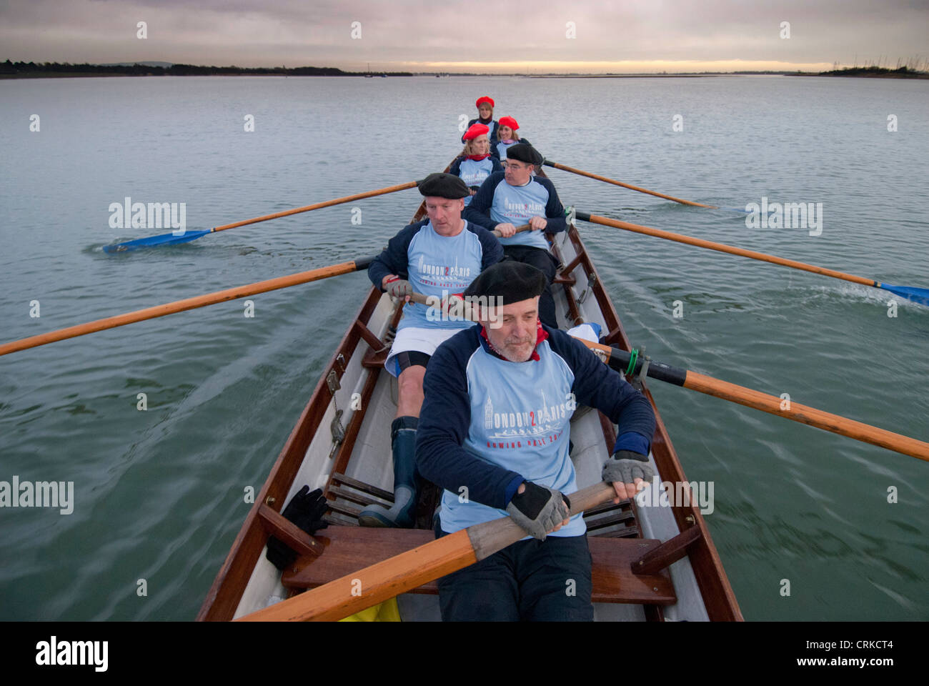 Rowing crew aboard a skiff in Langstone Harbour, near Hayling Island ...