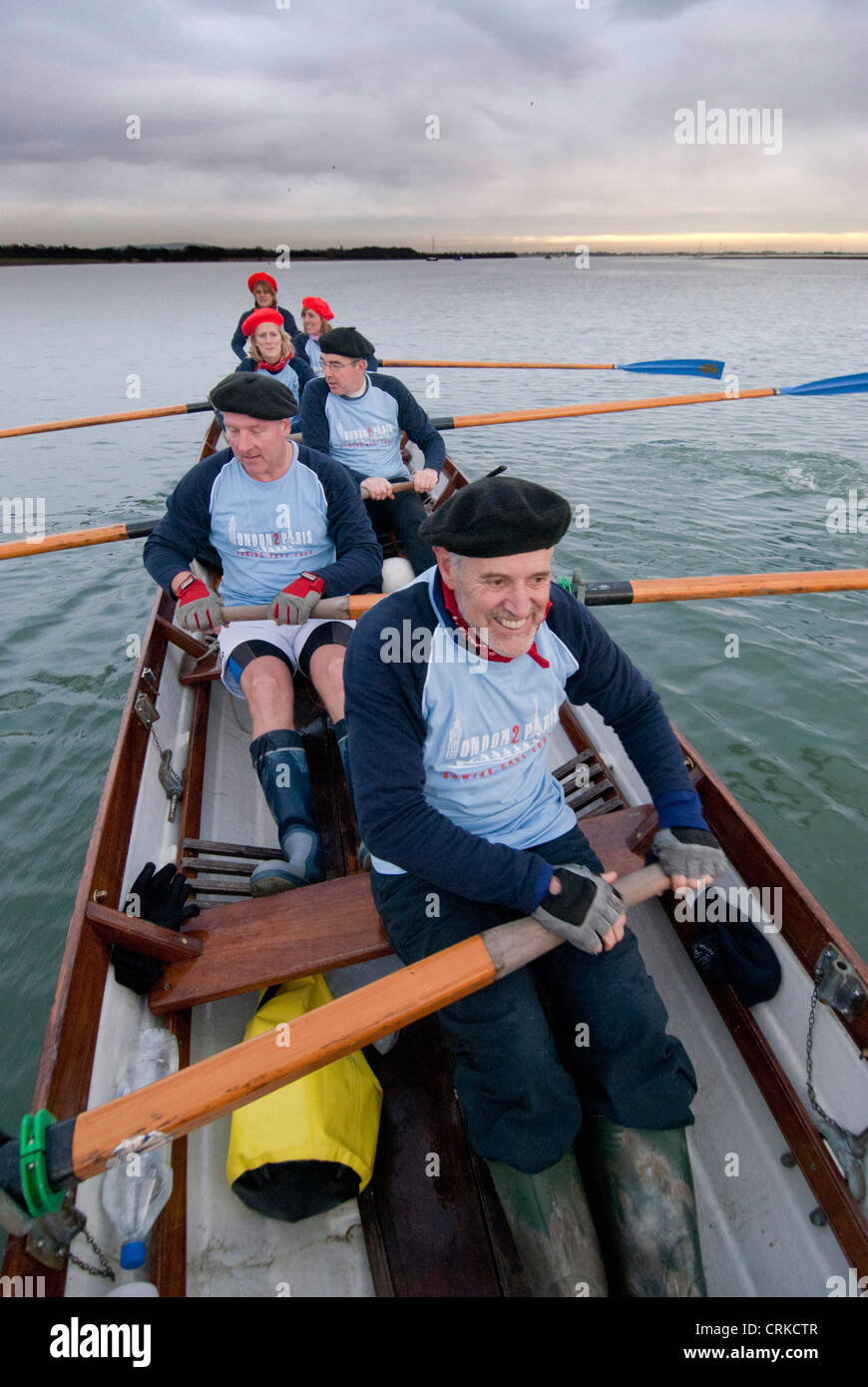 Rowing crew aboard a skiff in Langstone Harbour, near Hayling Island ...