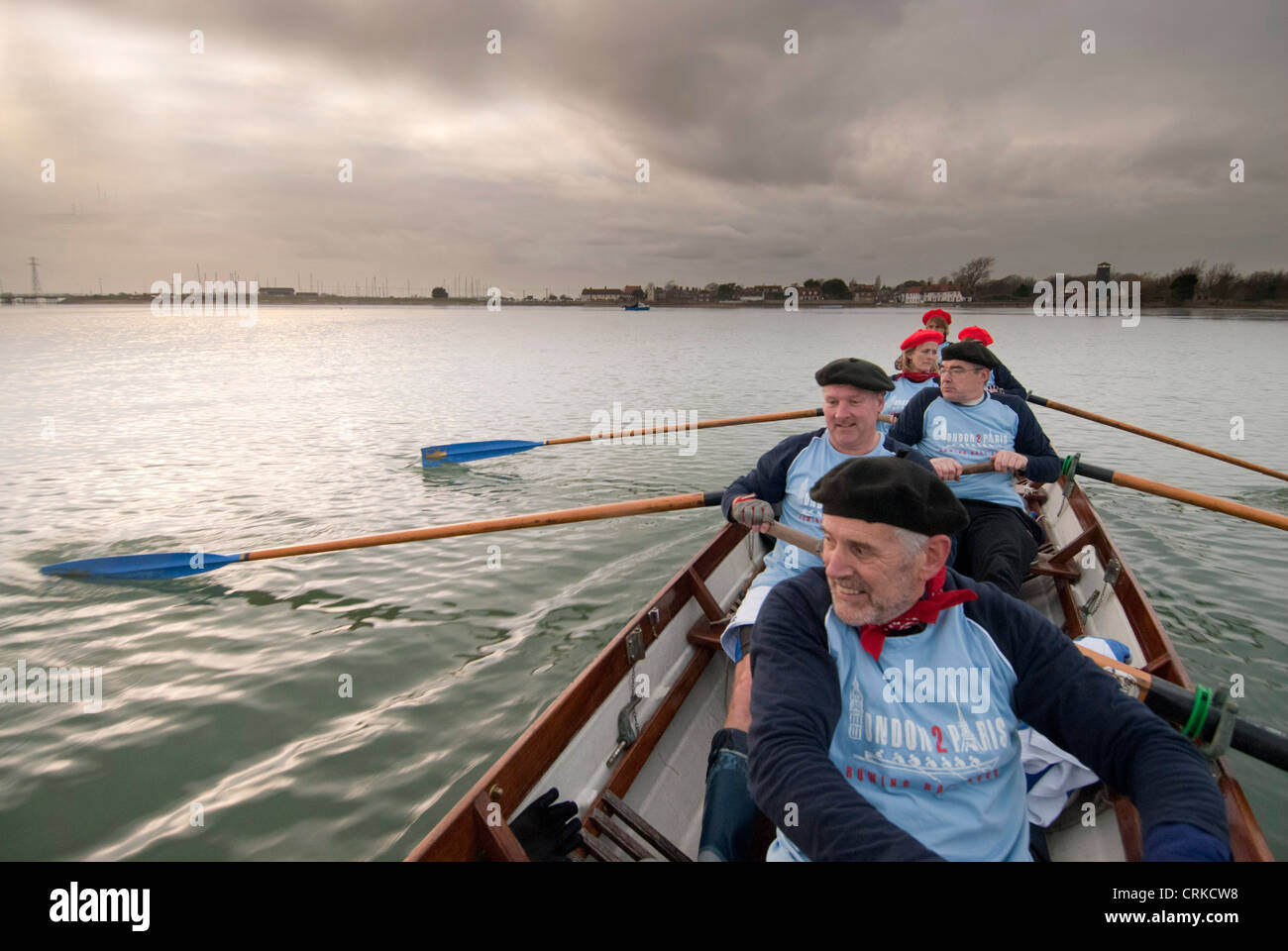 Rowing crew aboard a skiff in Langstone Harbour, near Hayling Island ...