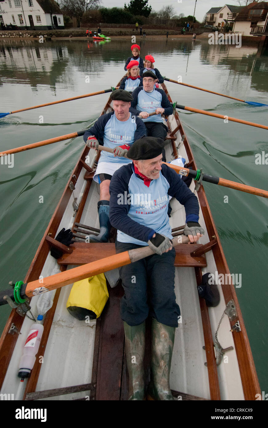 Rowing crew aboard a skiff in Langstone Harbour, near Hayling Island ...
