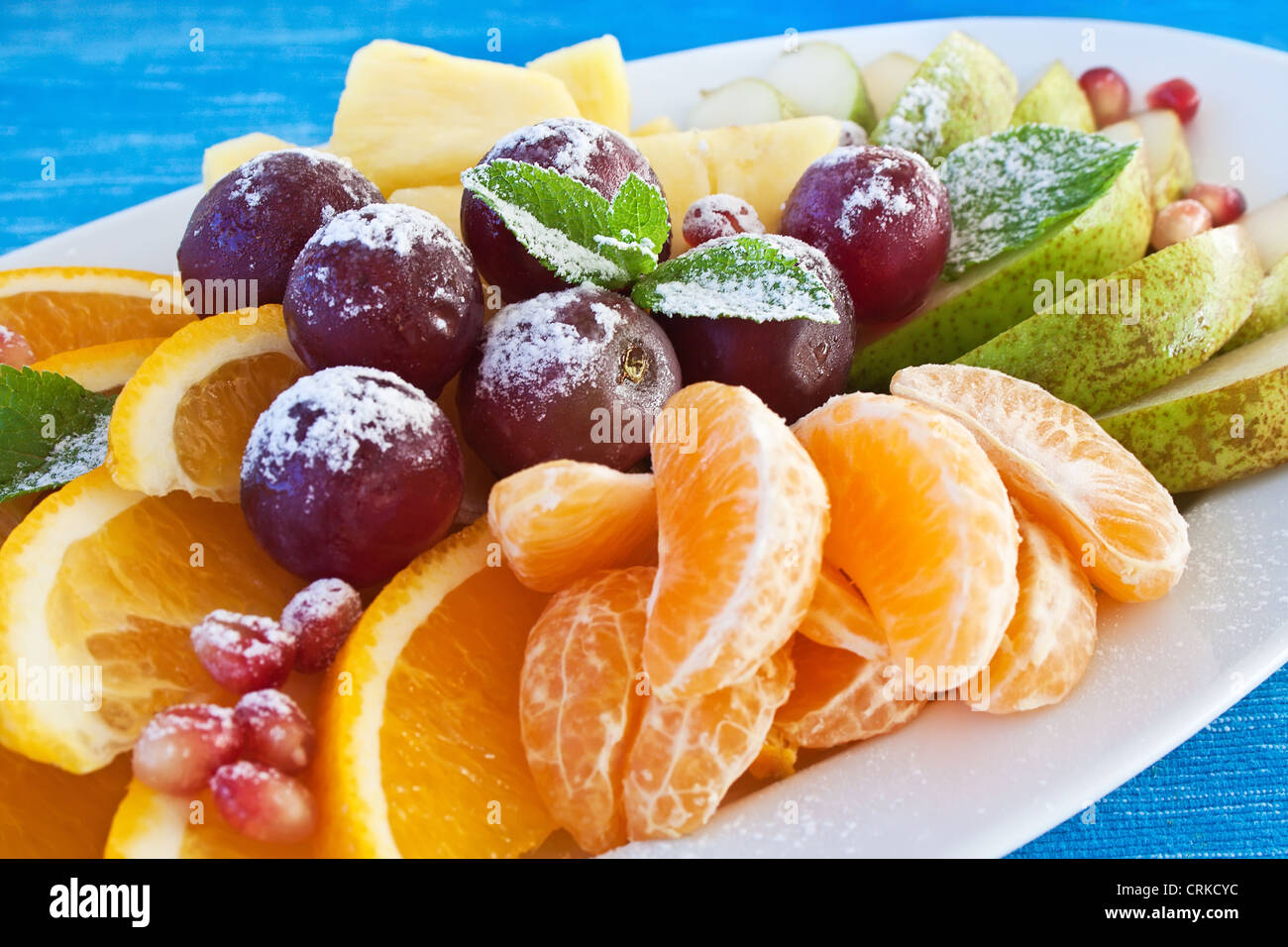 Colorful Fruits in powdered sugar on blue background Stock Photo - Alamy