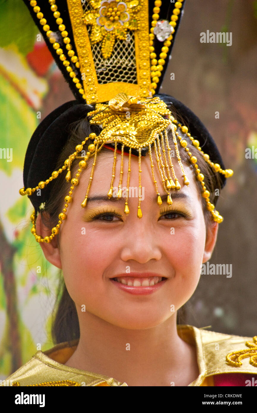 A local Chinese girl dressed in traditional clothes perform on a street ...
