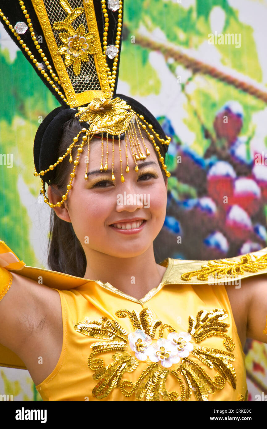 A local Chinese girl dressed in traditional clothes perform on a street ...