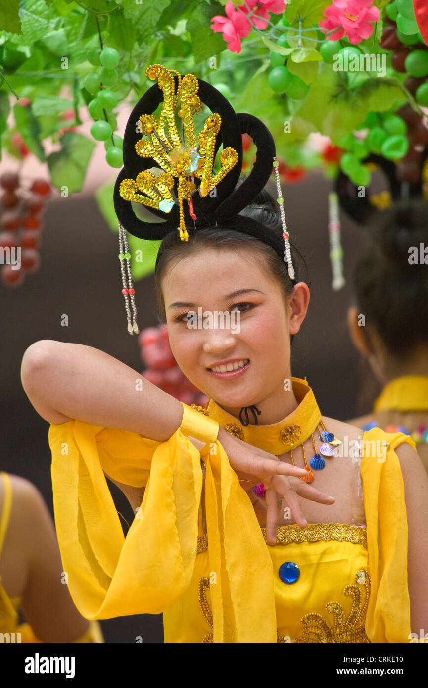 A local Chinese girl dressed in traditional clothes perform on a street ...