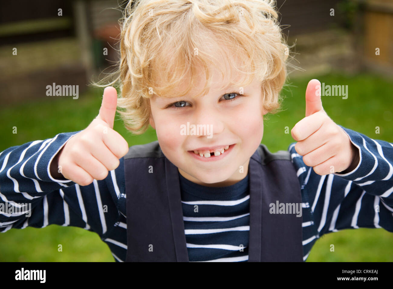Smiling boy giving thumbs-up outdoors Stock Photo - Alamy