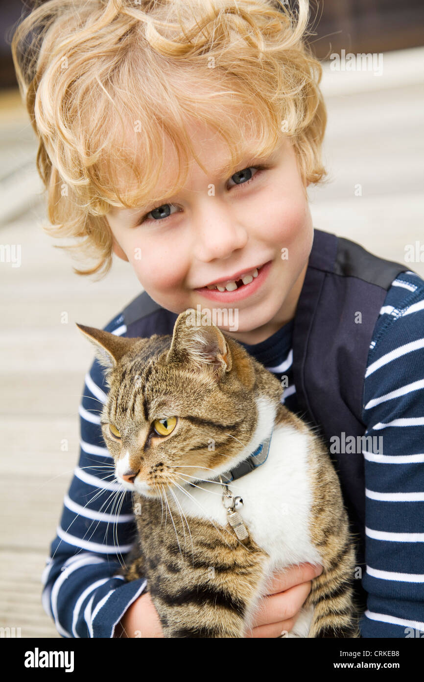 Smiling boy holding cat outdoors Stock Photo - Alamy