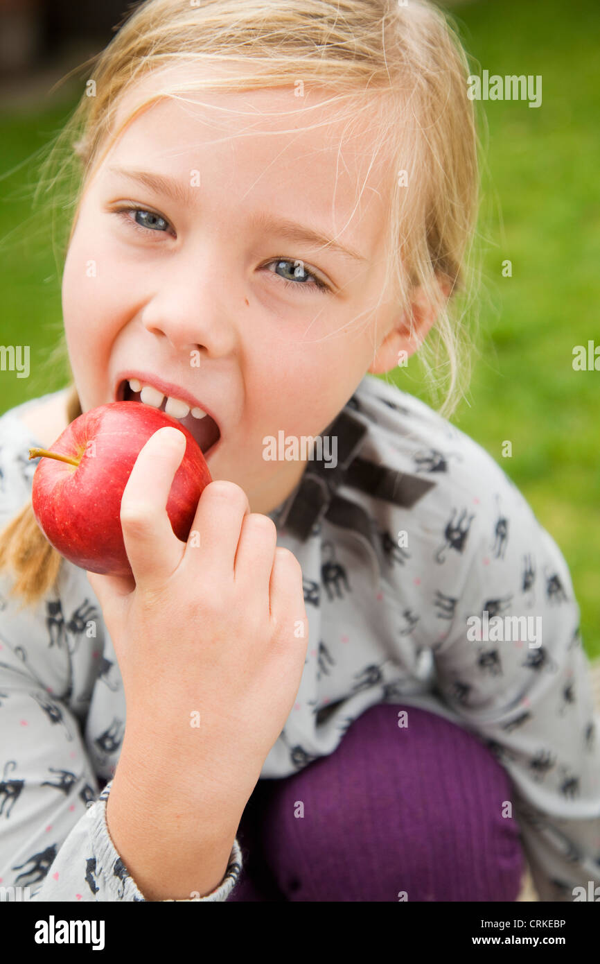 Girl eating fruit outdoors Stock Photo - Alamy